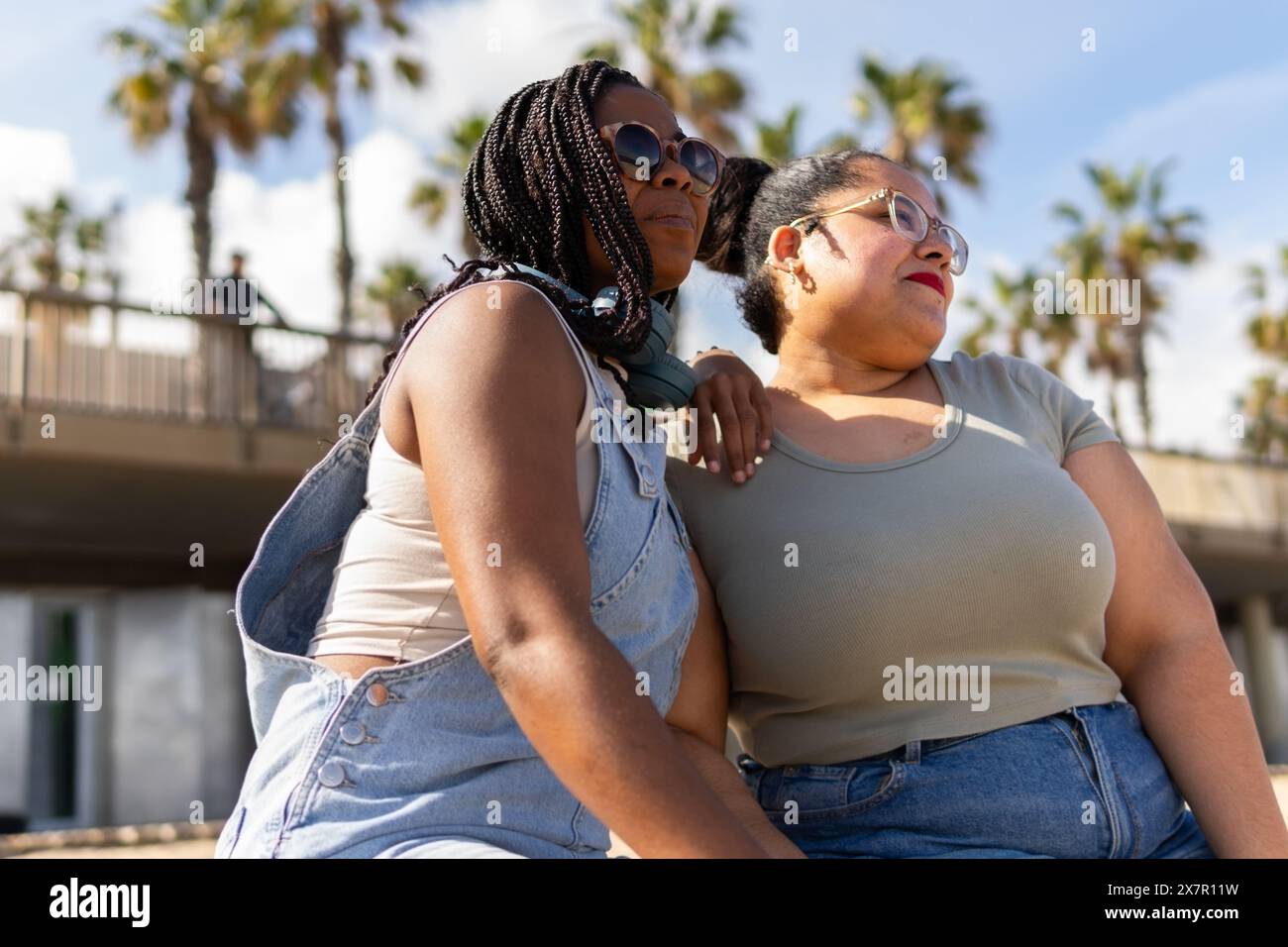 Two friends enjoy a sunny summer day together in Barcelona, surrounded ...