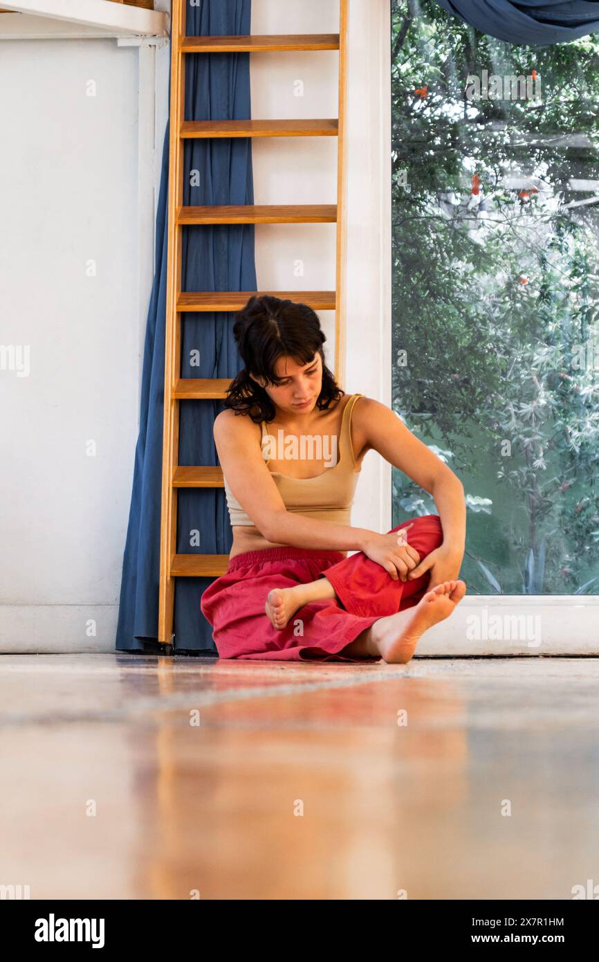 A person sits on the floor with eyes closed, connecting to the rhythm ...