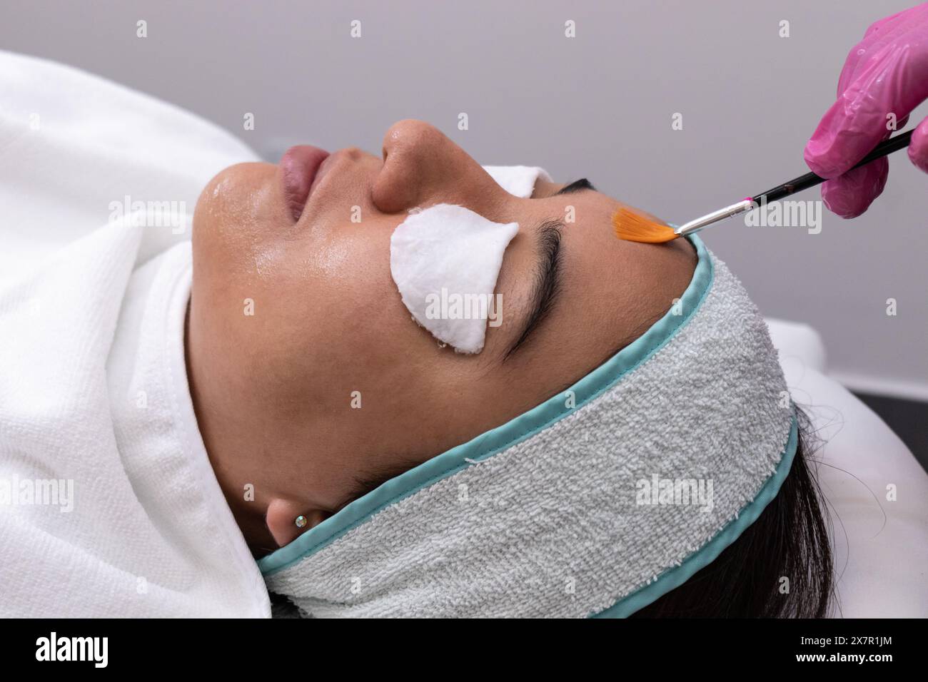 A client enjoys a facial treatment with a brush application at a ...