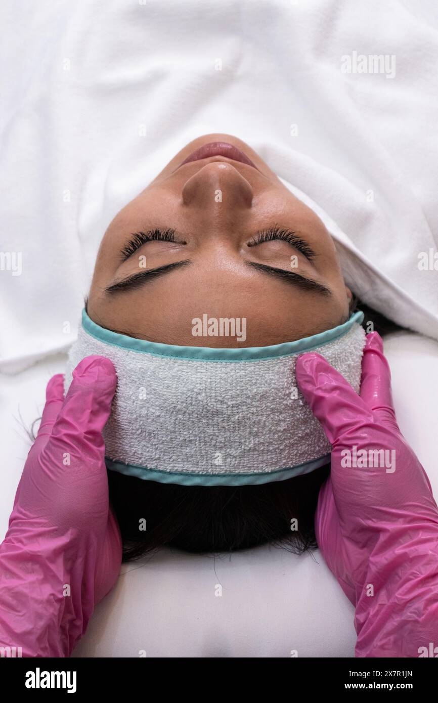 A serene woman enjoys a relaxing facial treatment, symbolizing the ...