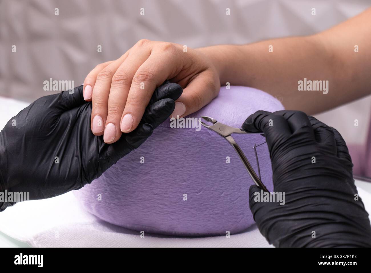 A close-up view showcasing a professional manicurist providing a nail ...