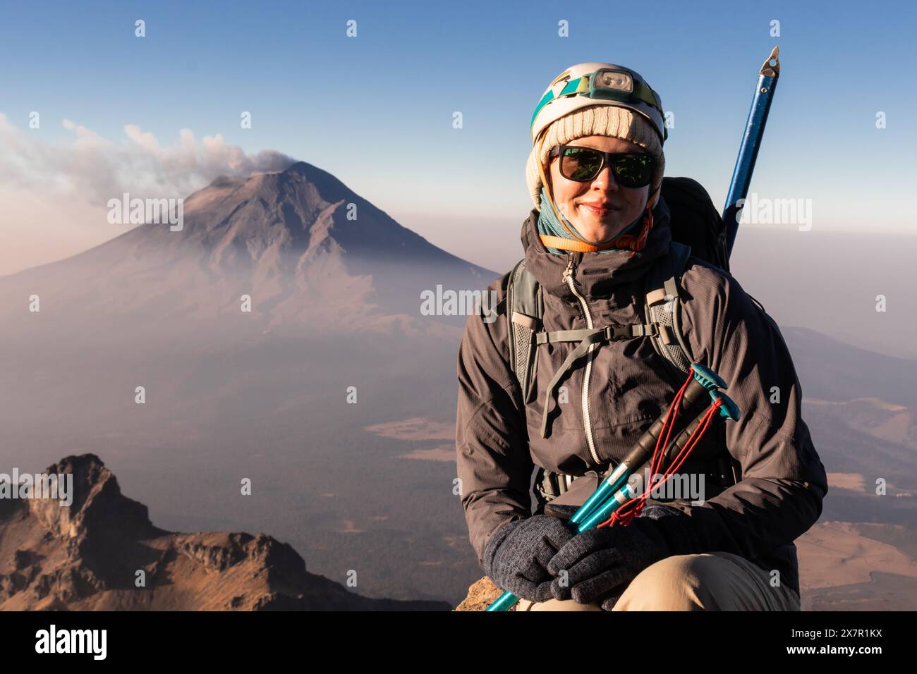 Smiling hiker in gear poses with the majestic Iztaccihuatl volcano ...