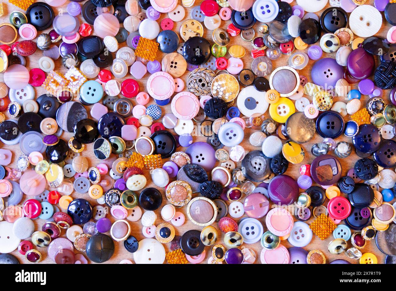 A vibrant collection of assorted buttons forms a textured mosaic, perfect for sewing and design ...