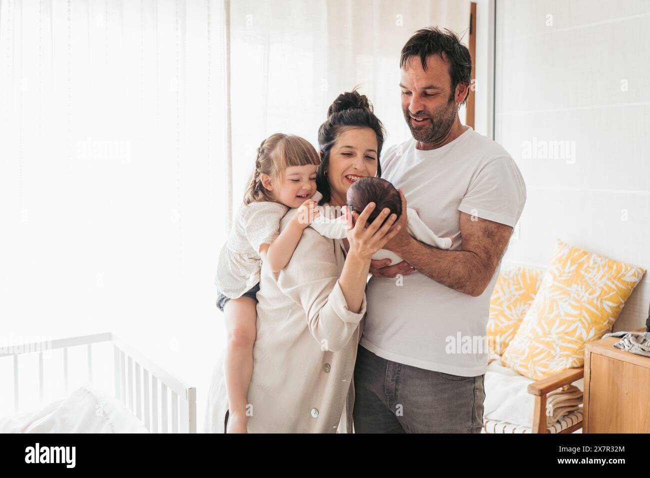 A family shares a tender moment as they embrace and admire their ...