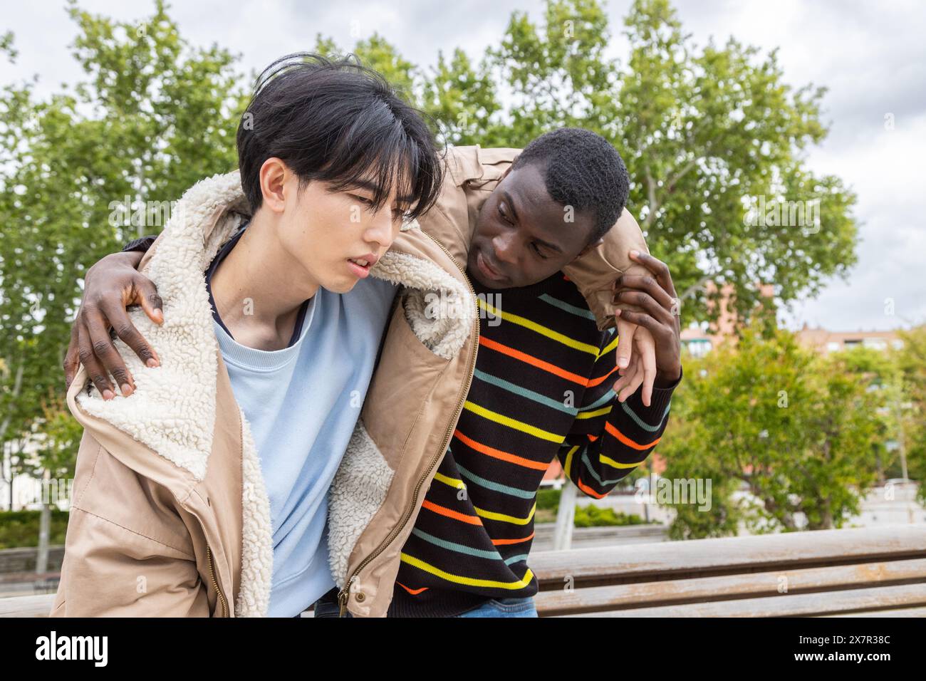 A compassionate scene of a man supporting his friend who is suffering ...