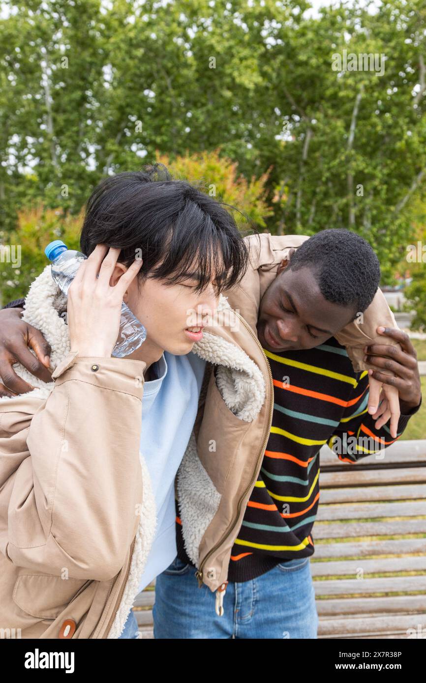 A compassionate scene unfold outdoors where a man supports a woman ...