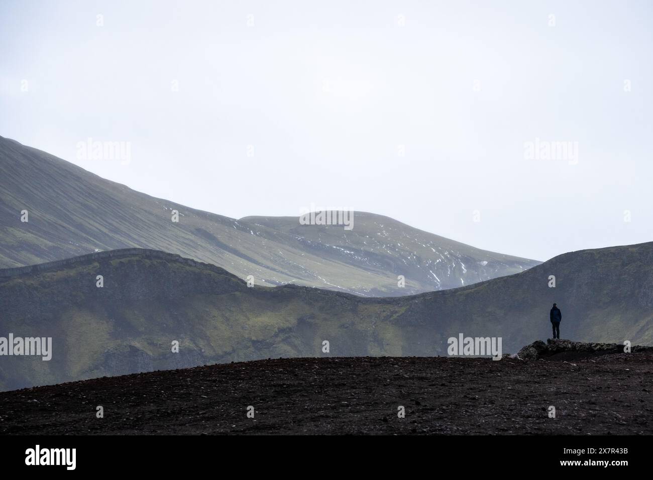 A lone person stands against the backdrop of the expansive and serene ...