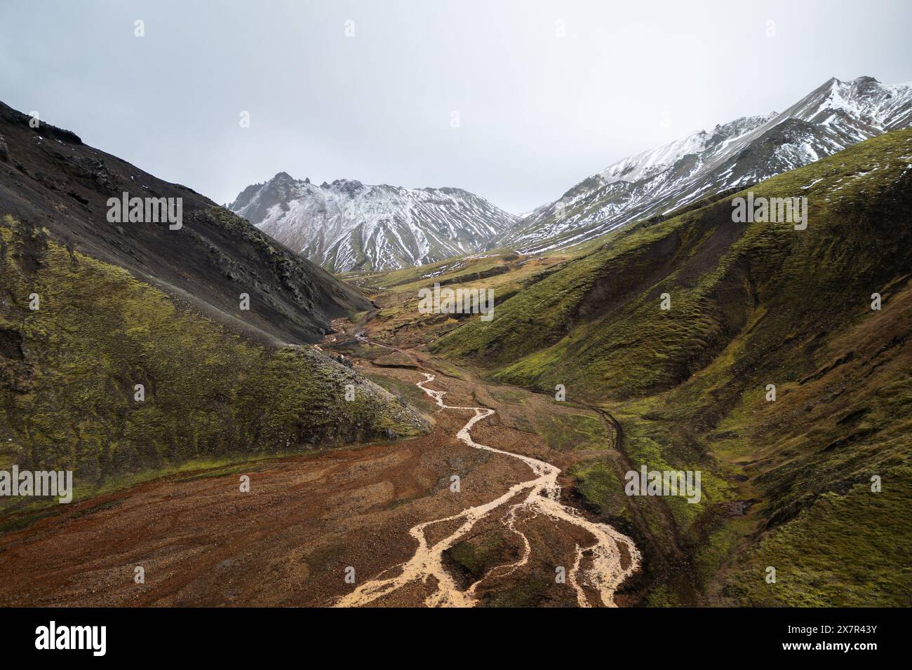 Majestic Erial Highlands with snow-capped peaks and a winding path ...