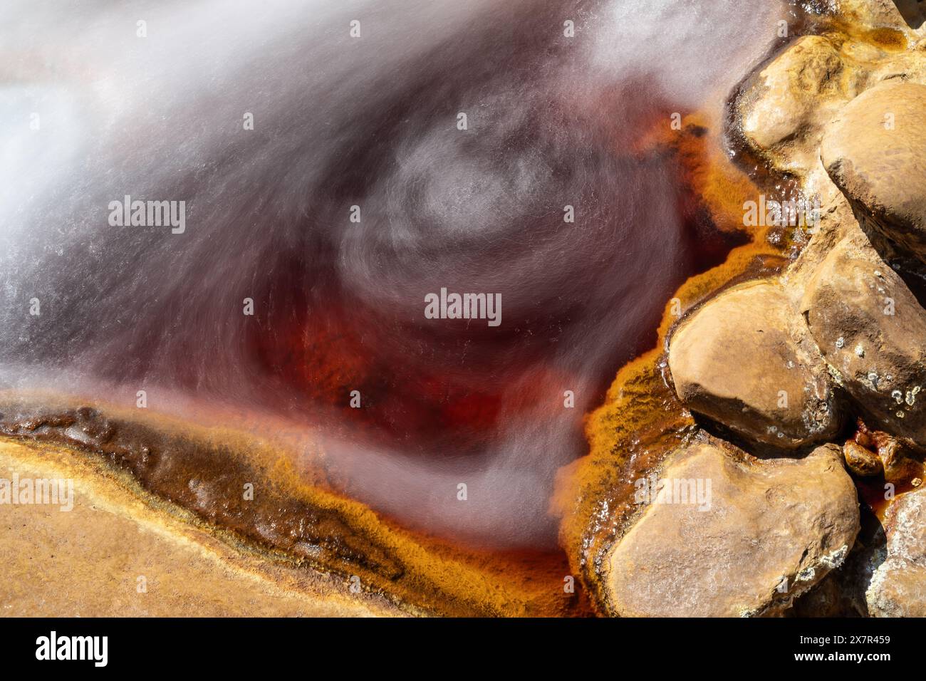 Close-up image capturing the dynamic swirls of red and orange water in ...