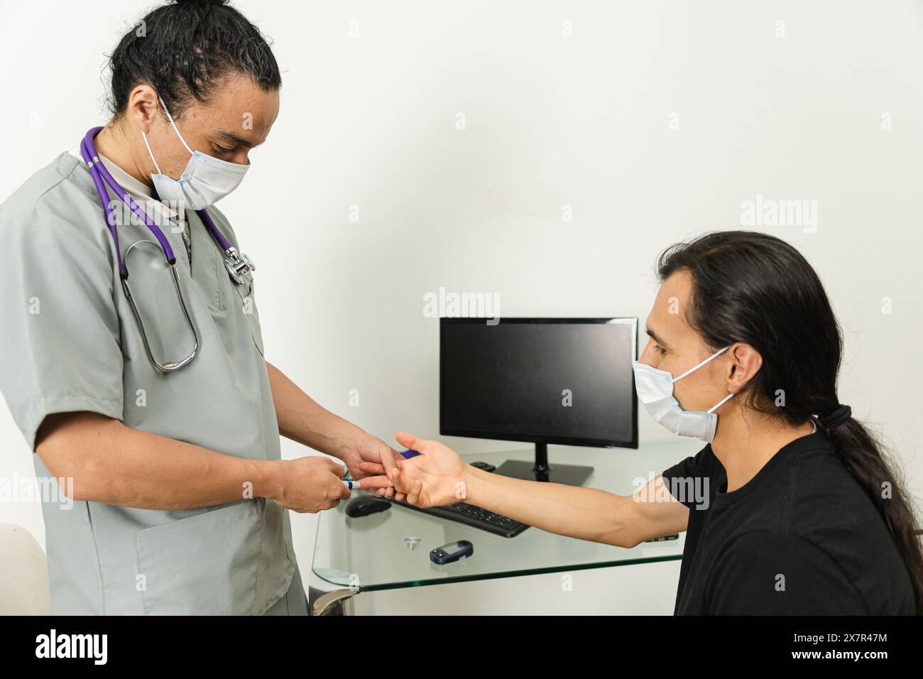 A healthcare professional, wearing a medical mask and scrubs, performs ...