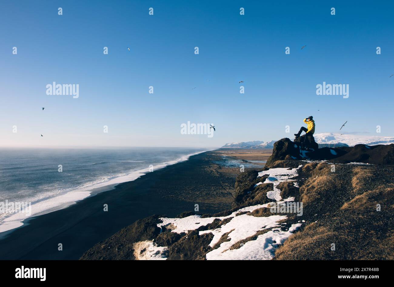 A solitary person perched on a rocky outcrop overlooking the expansive ...