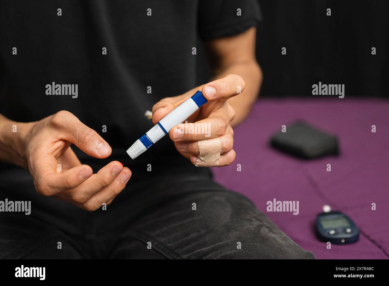 An individual uses a glucose meter and insulin lancet to test blood ...
