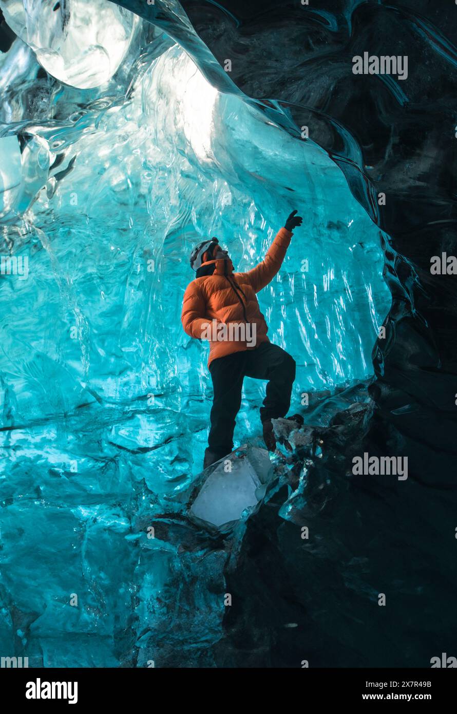 A traveler in vibrant orange attire points upward while exploring the ...