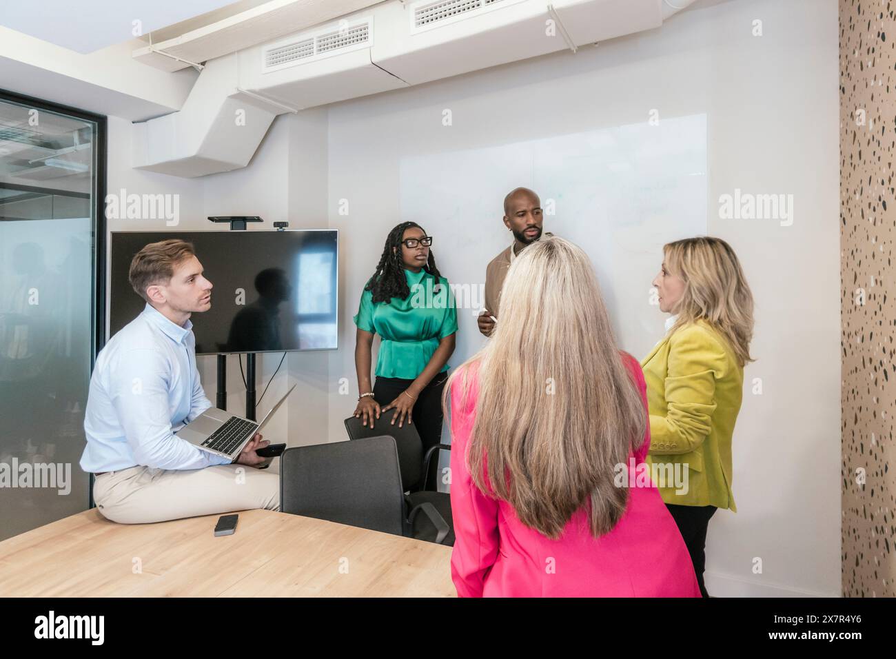 A diverse team collaborates in a modern coworking space, engaging in a ...