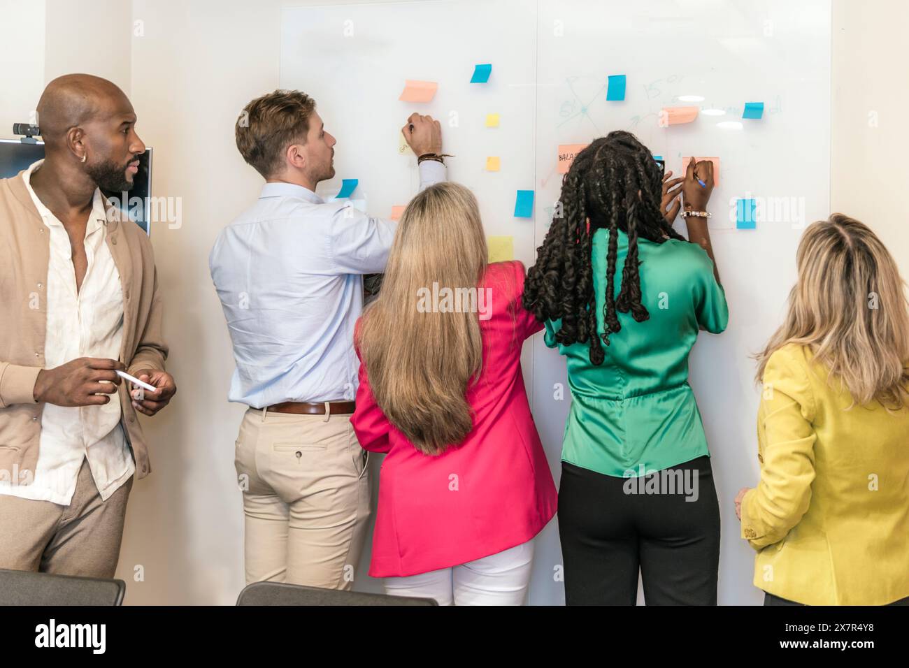 A multiethnic group of professionals collaboratively brainstorming with ...