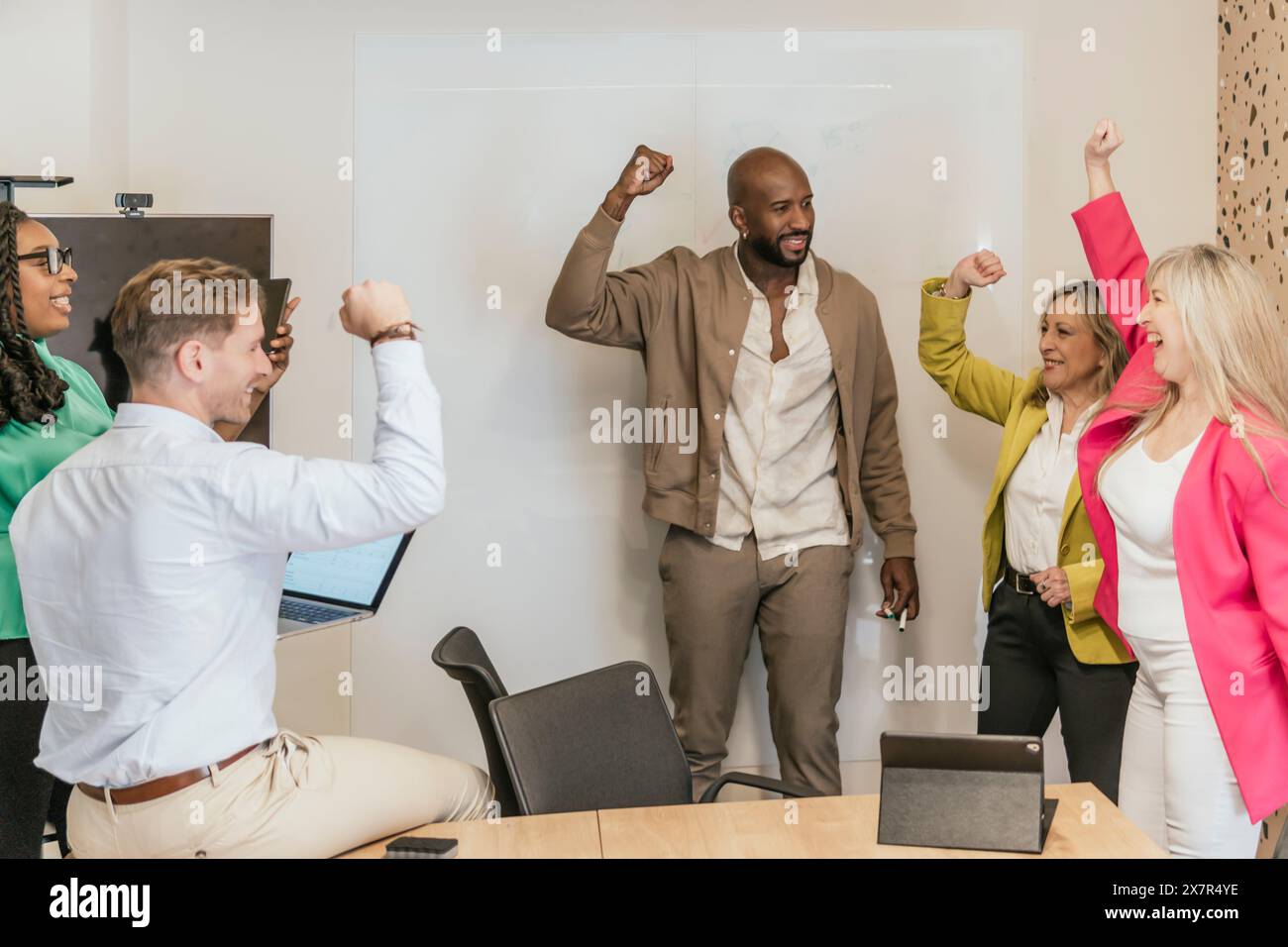 A diverse group of professionals cheerfully celebrates a victory in a ...