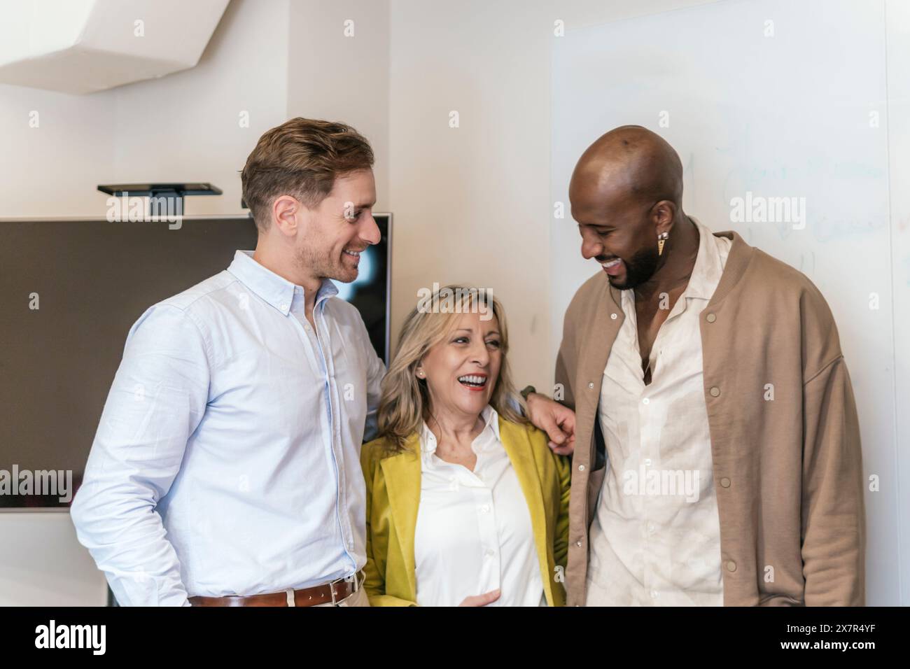 Three professionals share a light-hearted moment in a contemporary ...