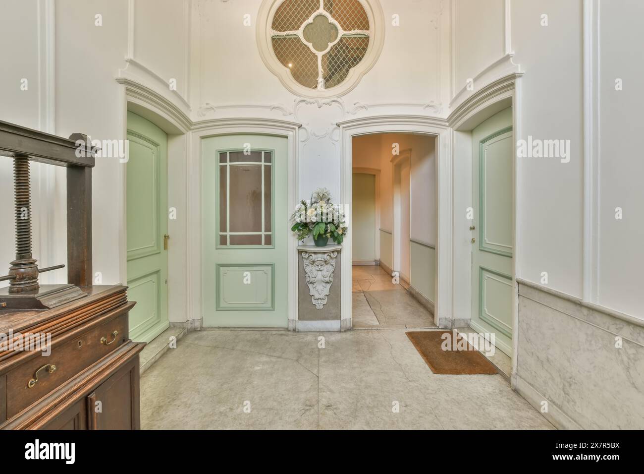 A sophisticated interior hallway featuring pastel green doors, ornate moldings, and a classical ...
