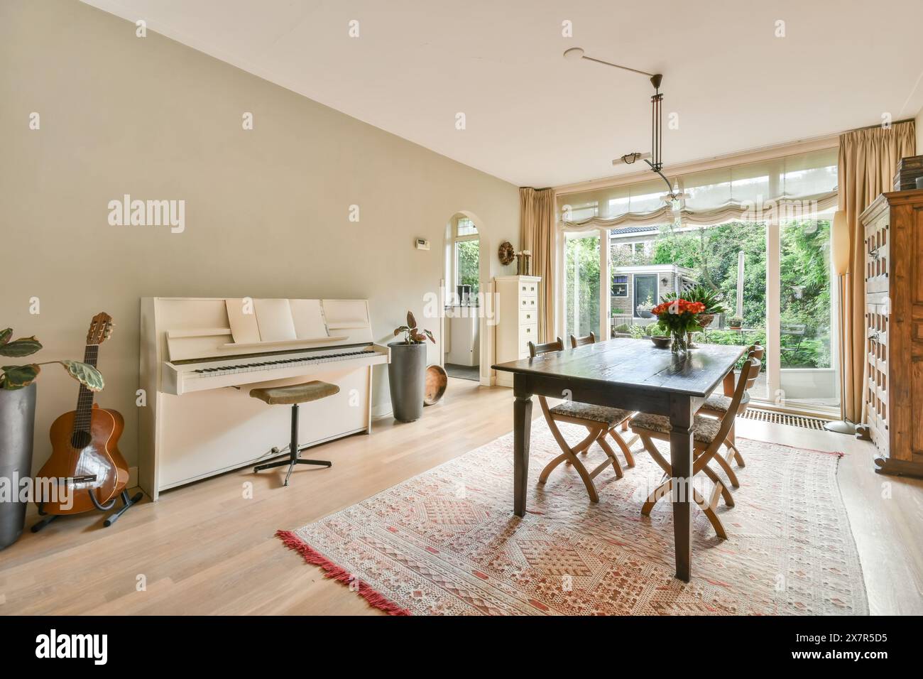 Bright and spacious dining room featuring a grand piano, wooden table ...