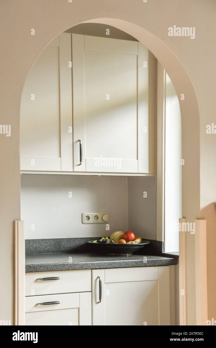A stylish kitchen nook featuring an arched alcove with white modern ...