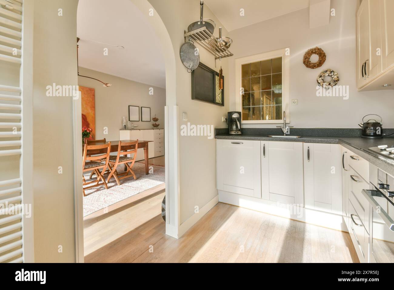 Compact and modern kitchen with an open archway leading to a warmly lit ...