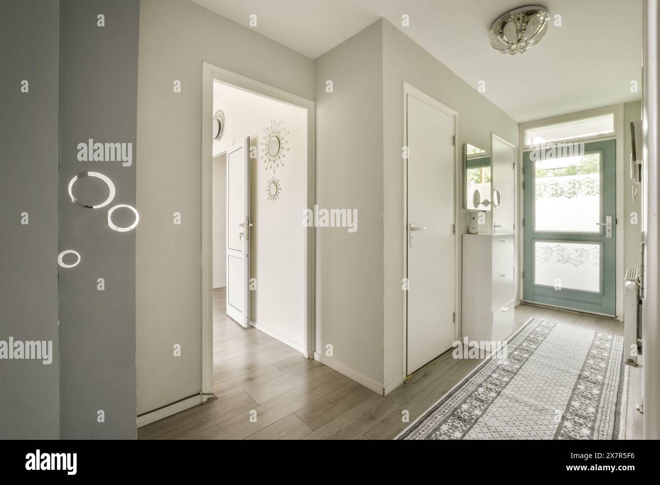 A well-lit, modern hallway in a house featuring neutral colors ...
