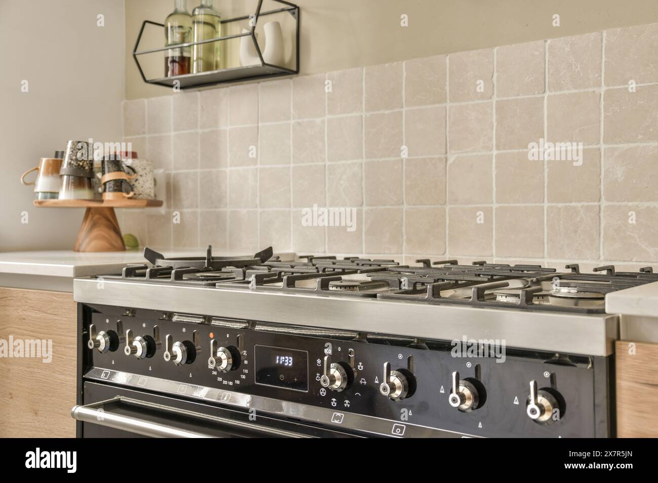 A sleek modern kitchen stove with digital clocks and multiple control ...