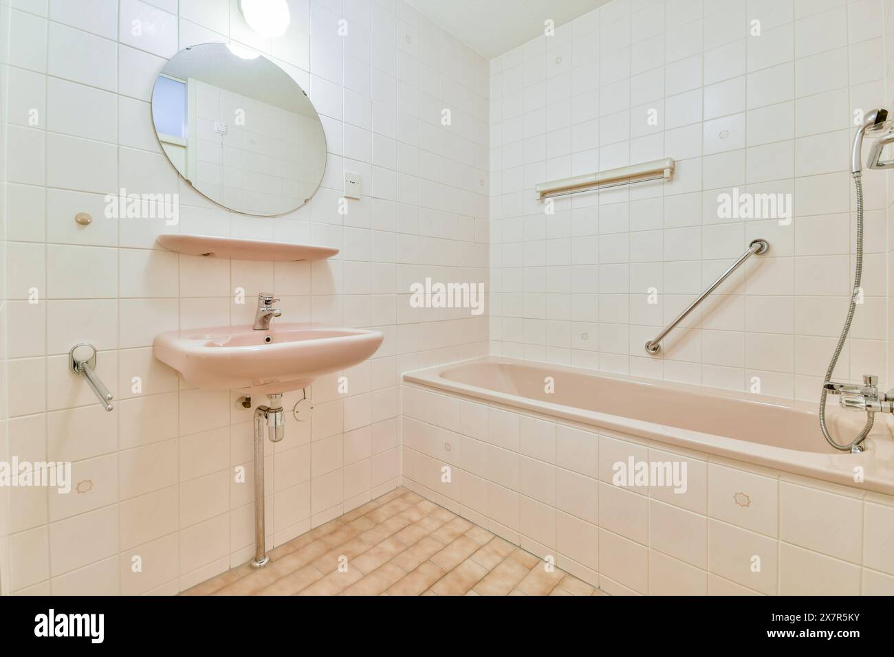 A clean and well-lit bathroom featuring a large bathtub, a pedestal ...