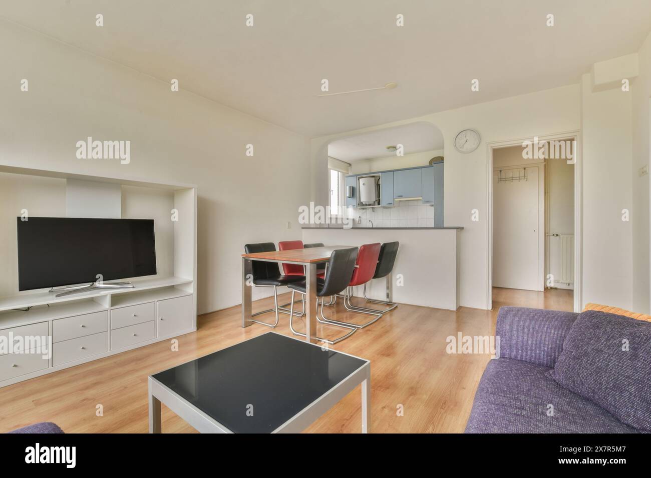 A contemporary open-plan living space featuring a lounge with a flat ...