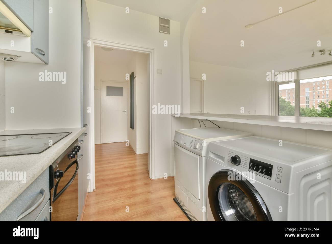 Bright, contemporary laundry room featuring a washer, dryer, ample ...