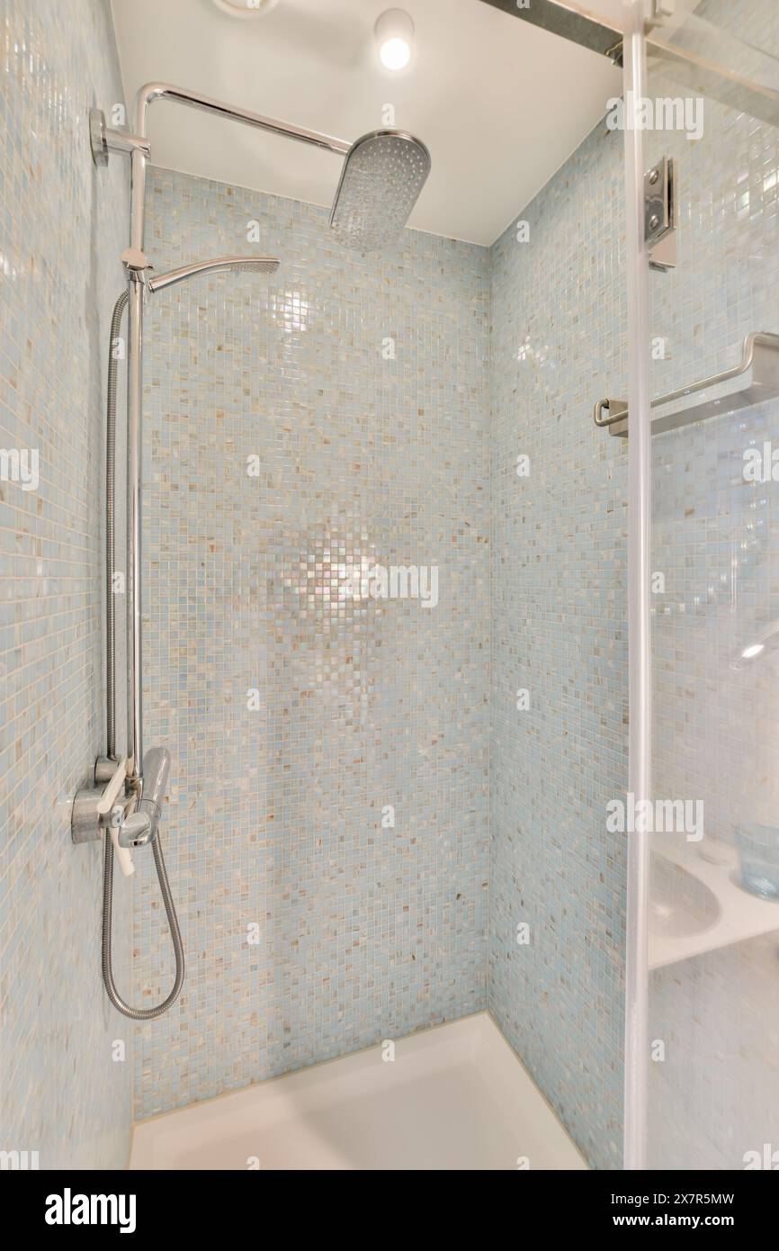 Modern bathroom shower with sleek fixtures and blue mosaic tile design ...