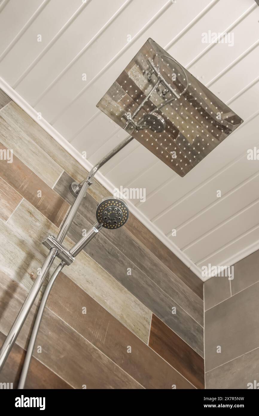 From below a contemporary square rain showerhead paired with a handheld ...