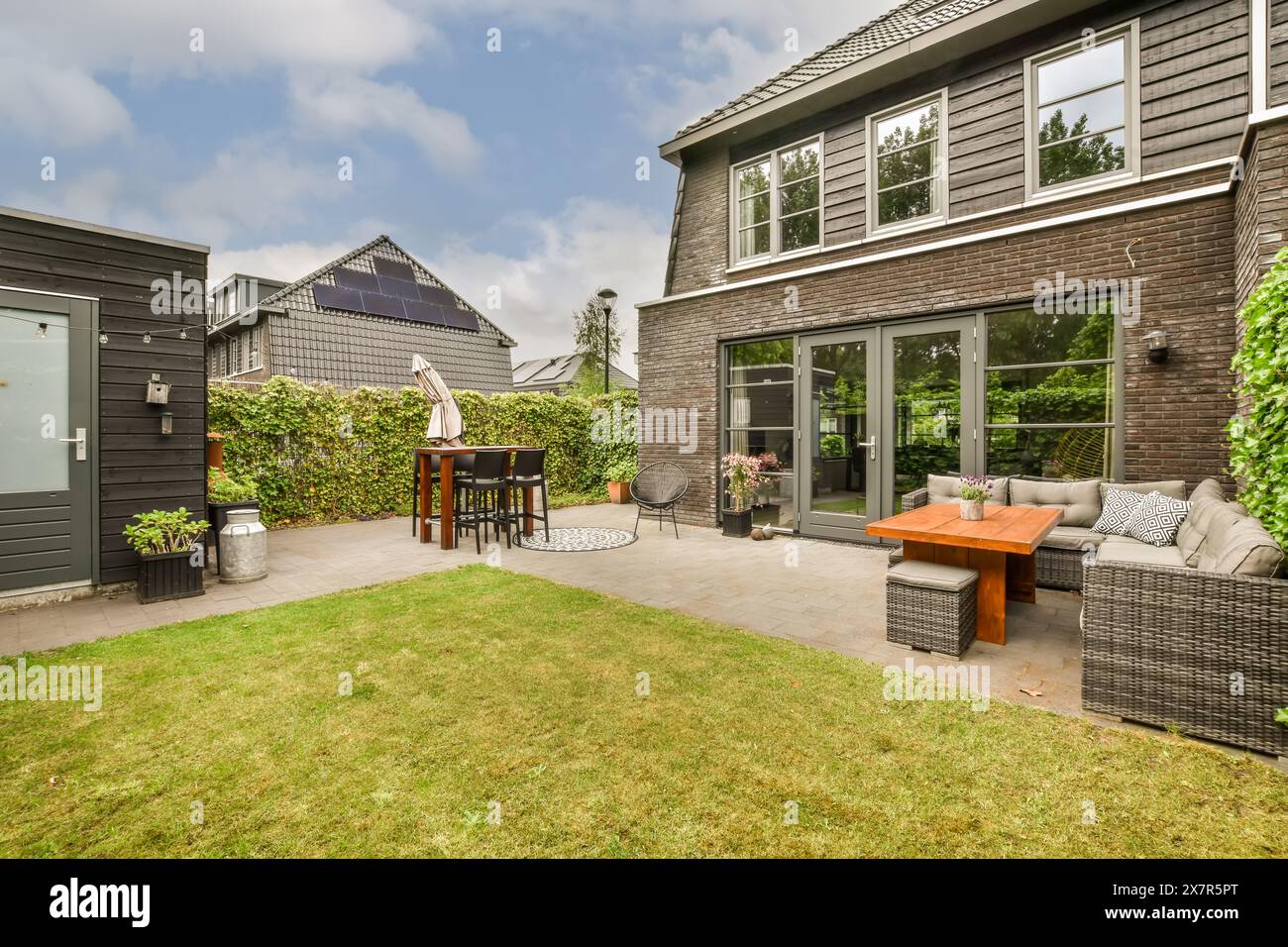 Cozy suburban backyard with patio furniture and lush greenery ...