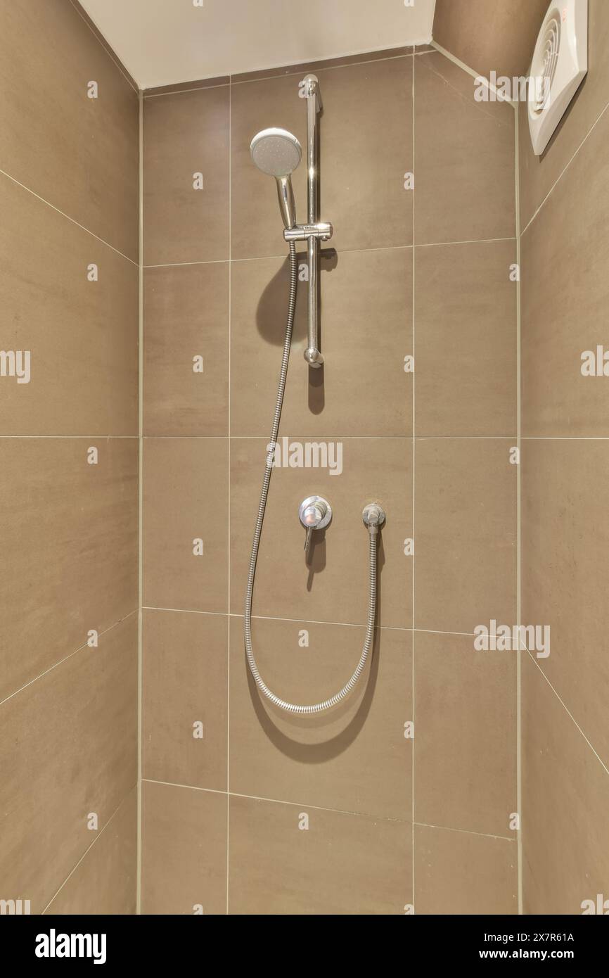 A close-up photo of a modern shower setup with a metallic adjustable ...