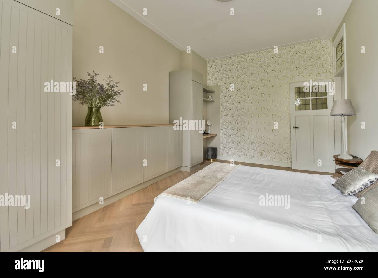 A well-lit and tastefully decorated bedroom featuring a large bed ...