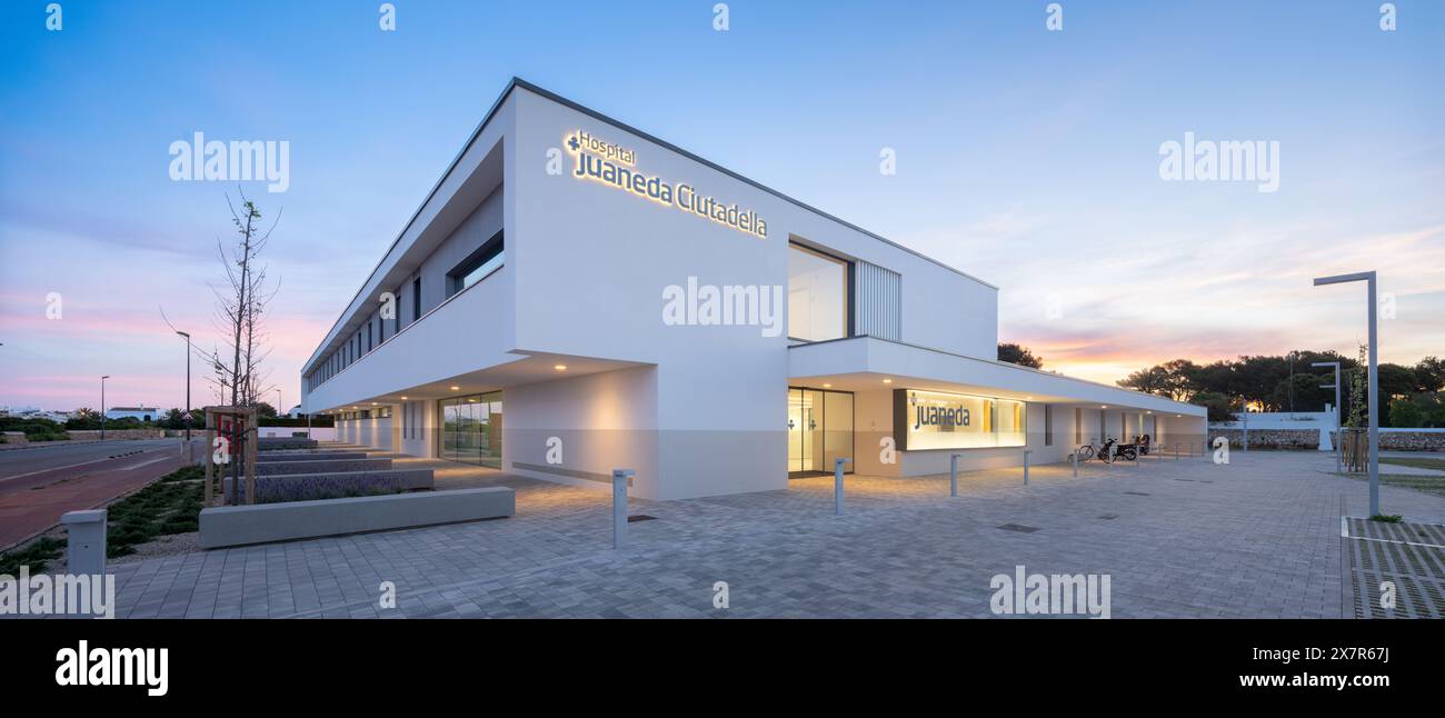 A contemporary hospital facility pictured at dusk, with the building's ...