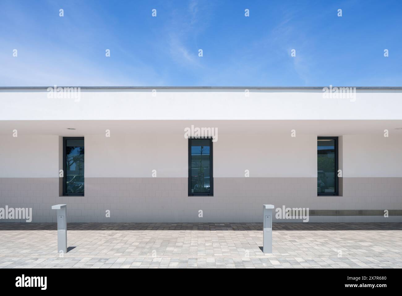 A contemporary hospital facade under a blue sky with minimalist design ...