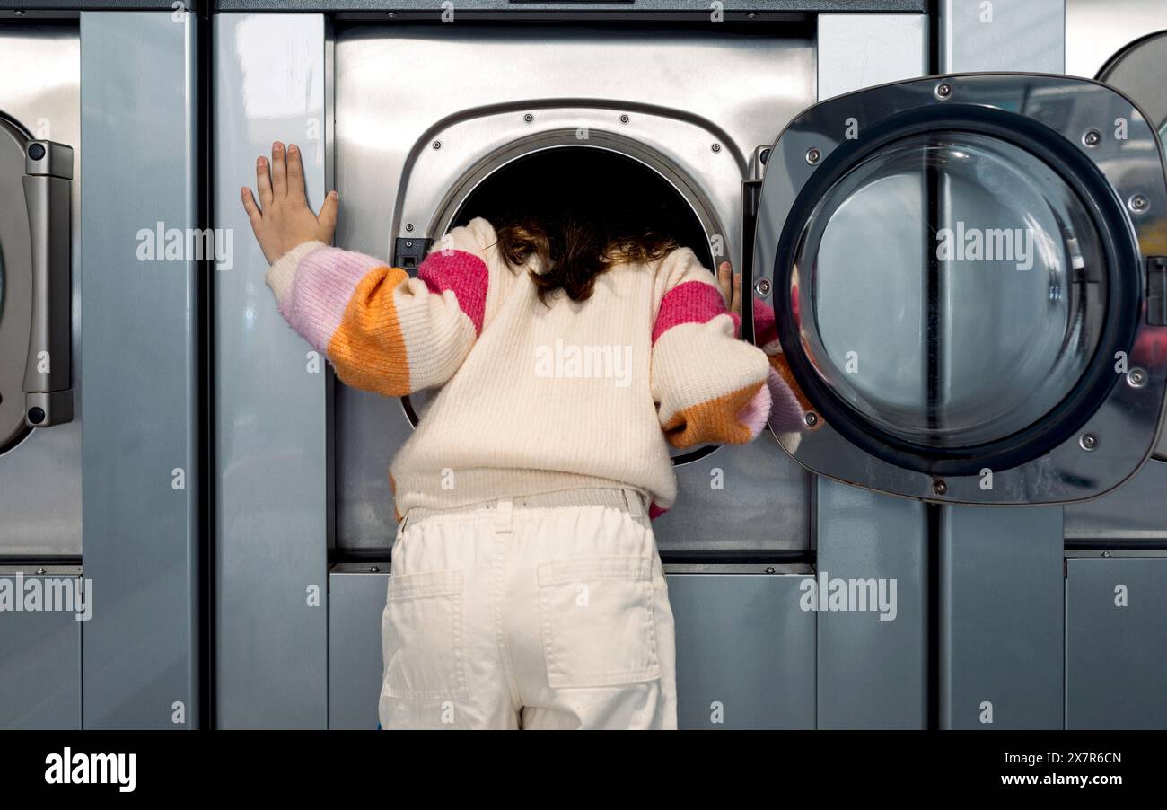 Back view of unrecognizable preteen girl leans forward to peer into a ...