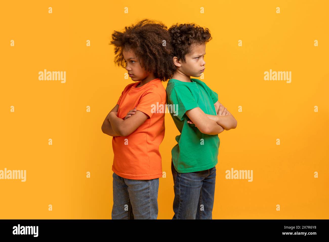 Two Young Boys Standing Back to Back With Arms Crossed Stock Photo - Alamy