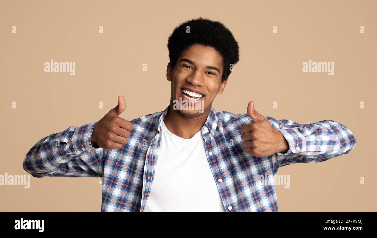 Like it. Happy guy showing thumbs up and smiling Stock Photo - Alamy