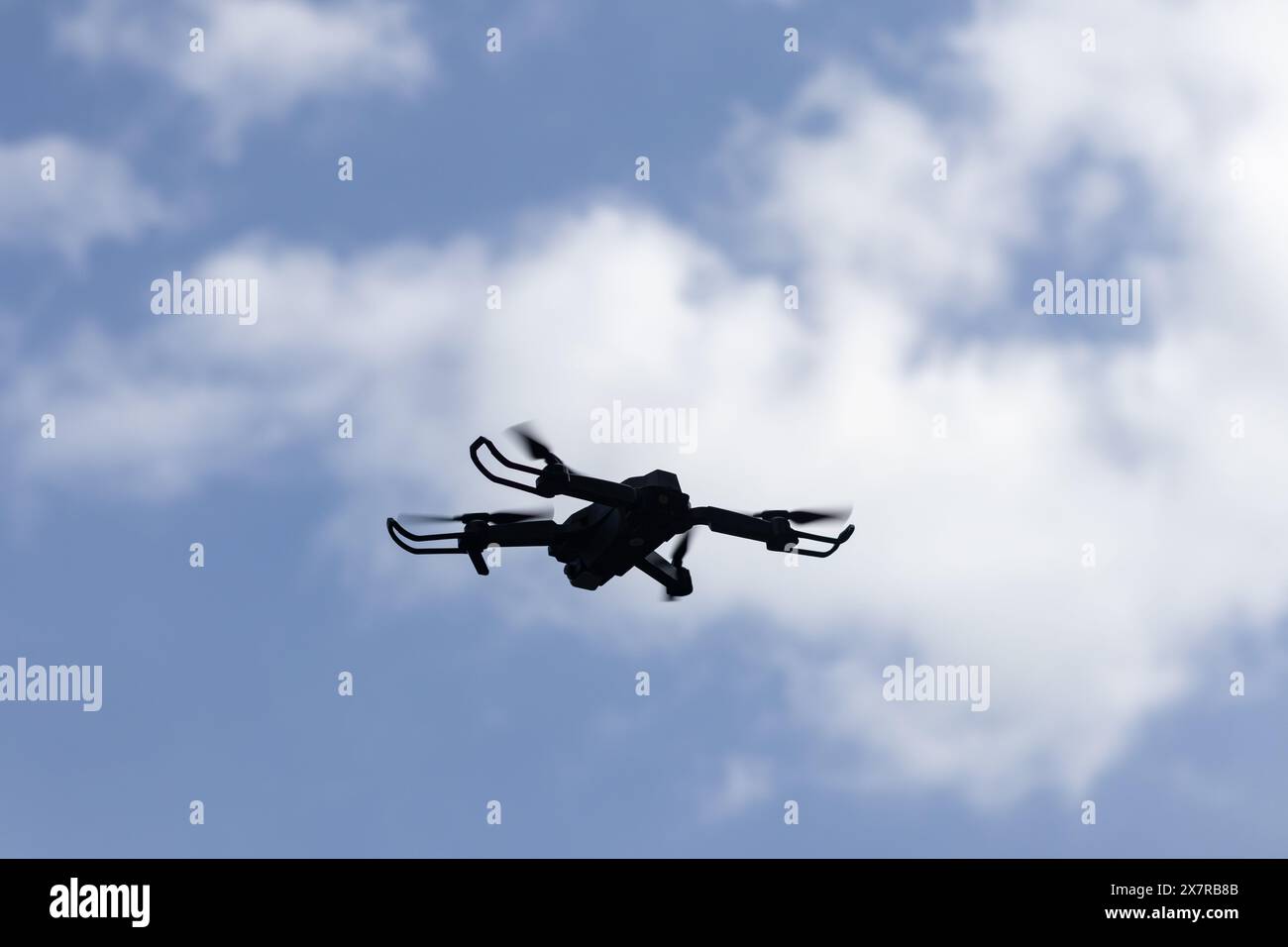 Drone flies in the air at a low altitude against a blue sky. Drone ...