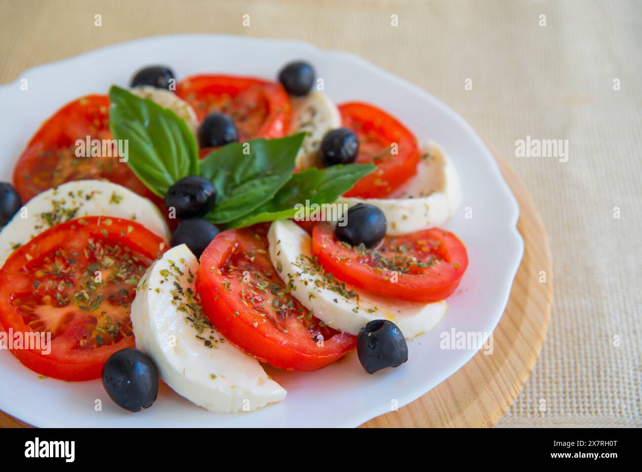 Mediterranean salad: sliced tomato, cottage cheese, black olives, basil ...