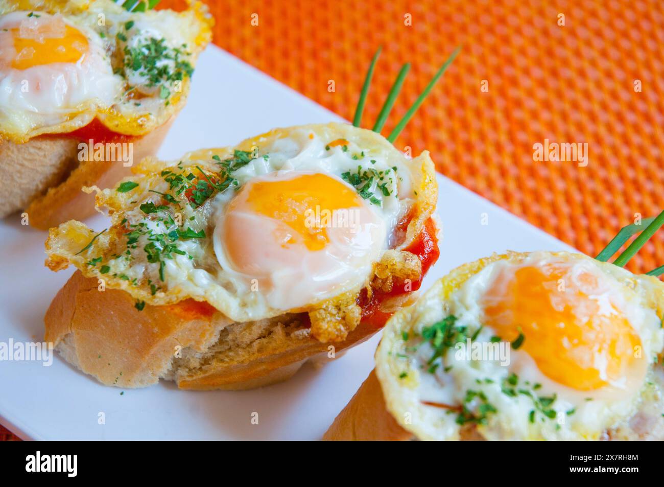 Spanish tapa: quail eggs and tomato sauce on toast. Close view Stock ...