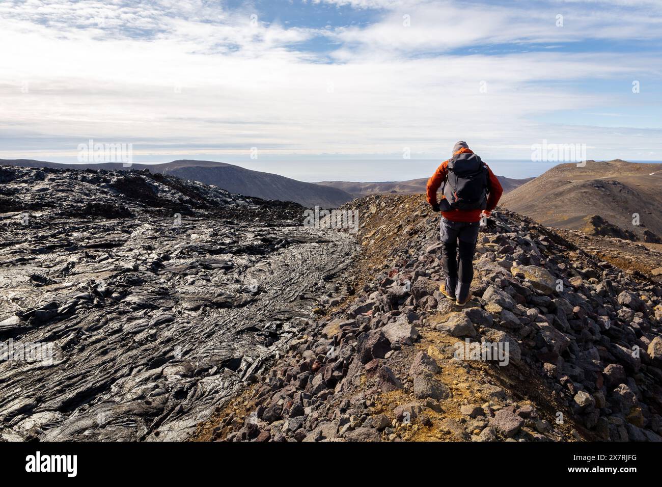 Male tourist walking at Fagradalsfjall volcano lava field, frozen ...