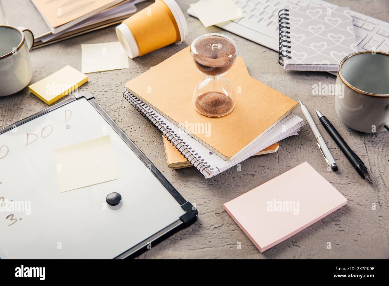 Crop of hourglass on home office table count measure time. Workplace of ...