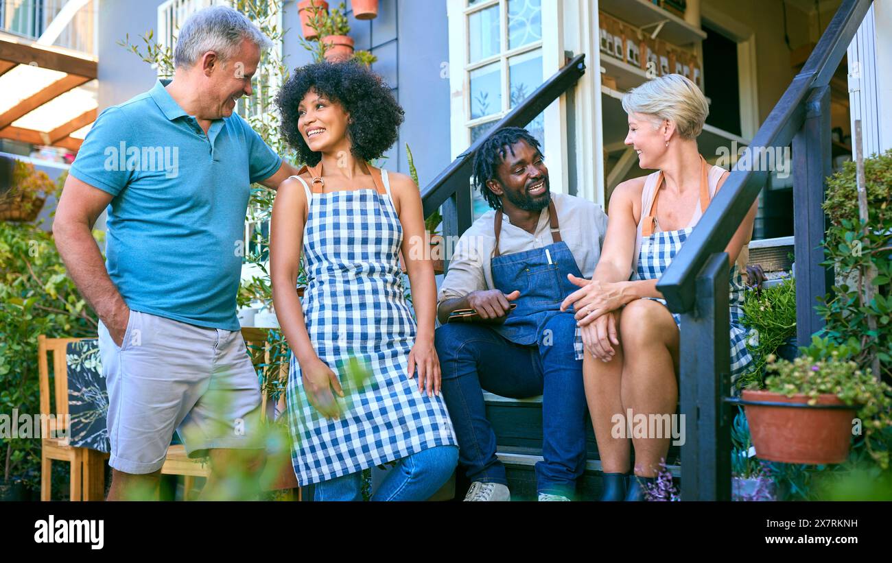 Portrait Of Smiling Staff And Management Team On Steps Outside Cafe Or ...