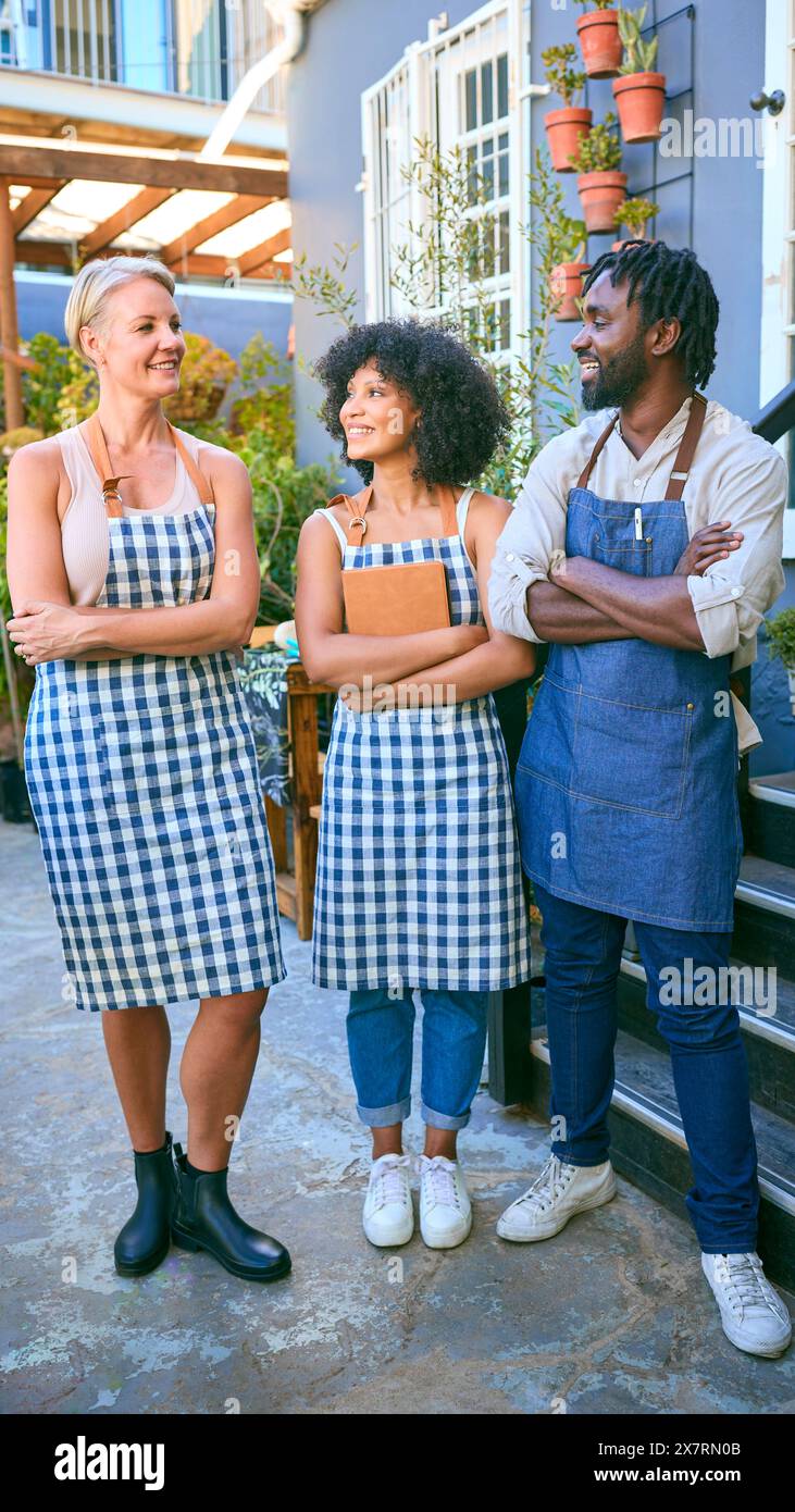 Portrait Of Smiling Staff Team Standing Outside Cafe Or Shop In Garden ...