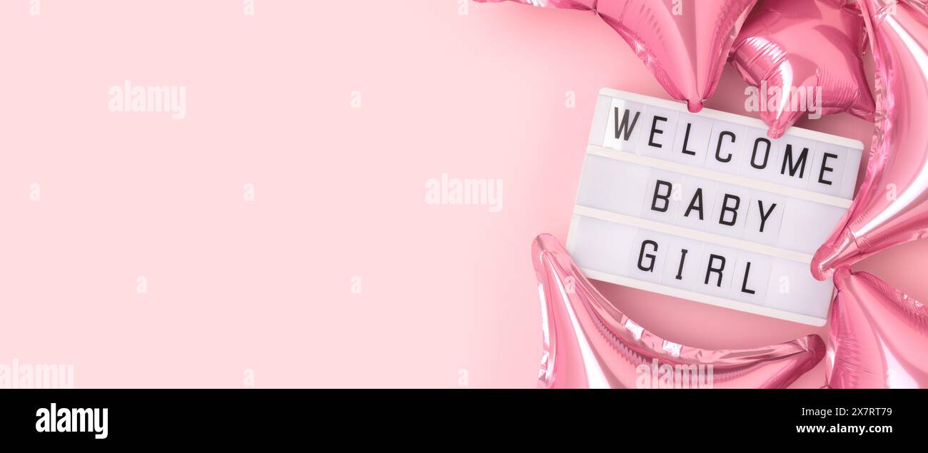 Welcome baby girl. Banner with lightbox and foil balloons in a pink ...