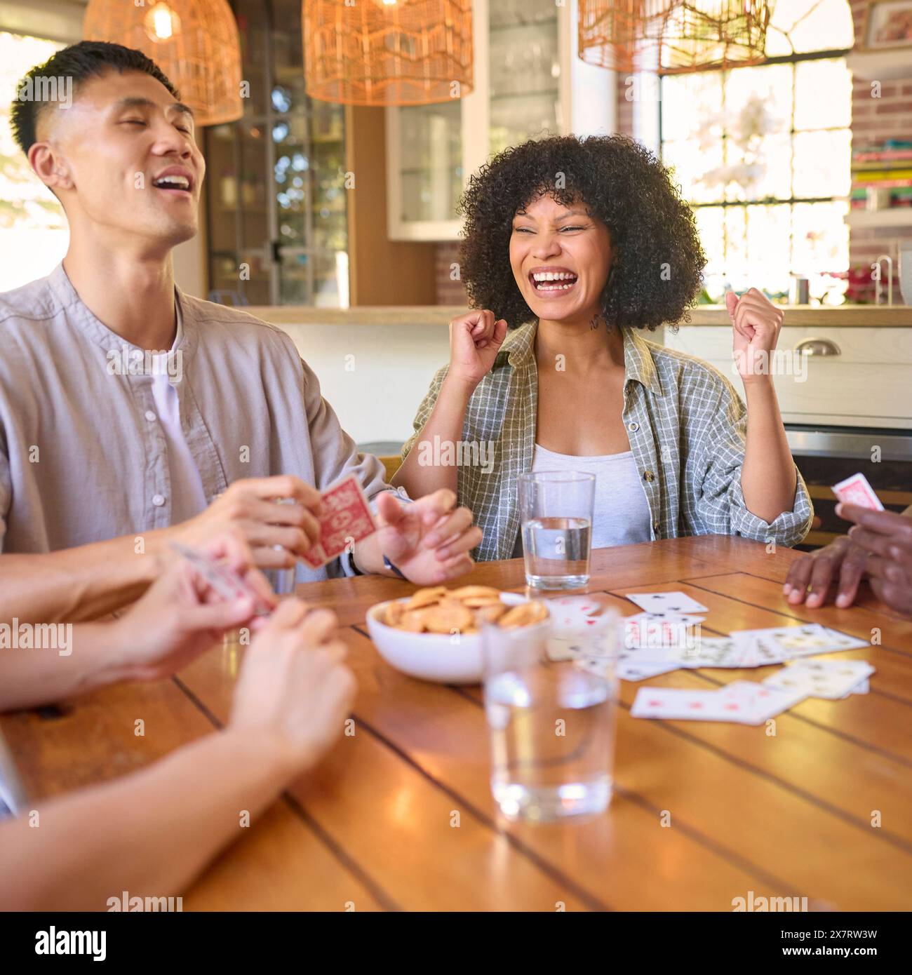 Group Of Multi-Racial Friends Sitting Around Table Playing Game Of ...