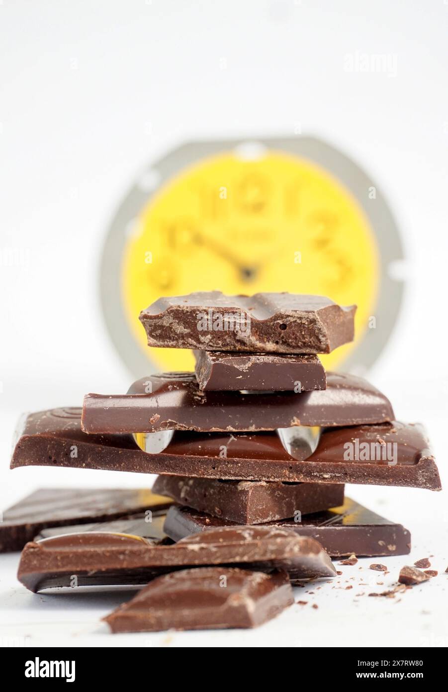stack of broken chocolate bars , on background alarm clock Stock Photo ...